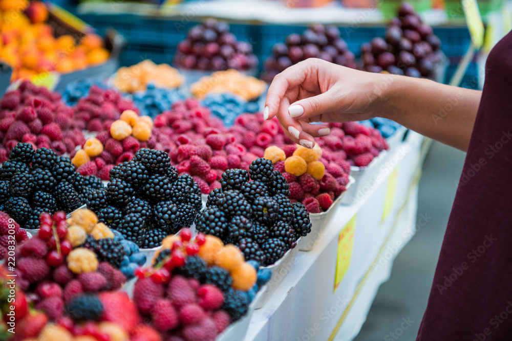 Marketplace with different fruits. Seller's hand on colorful berry ...