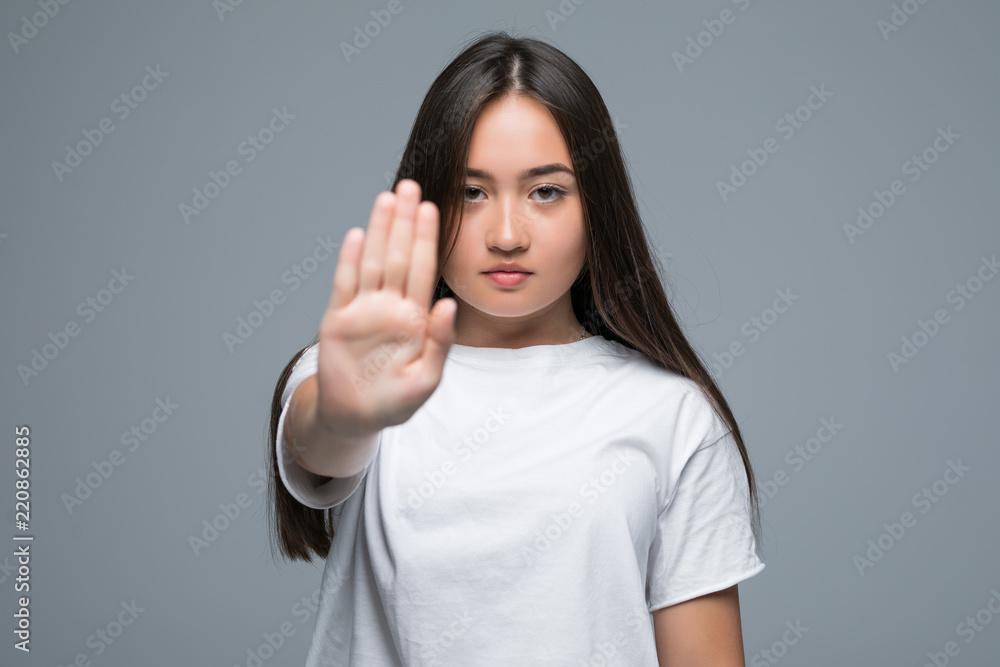 Portrait of a young asian woman standing with outstretched hand showing ...