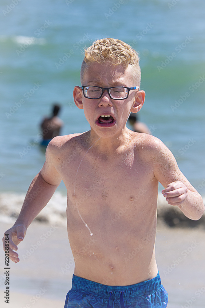 Boy at the beach running and screaming Stock Photo | Adobe Stock