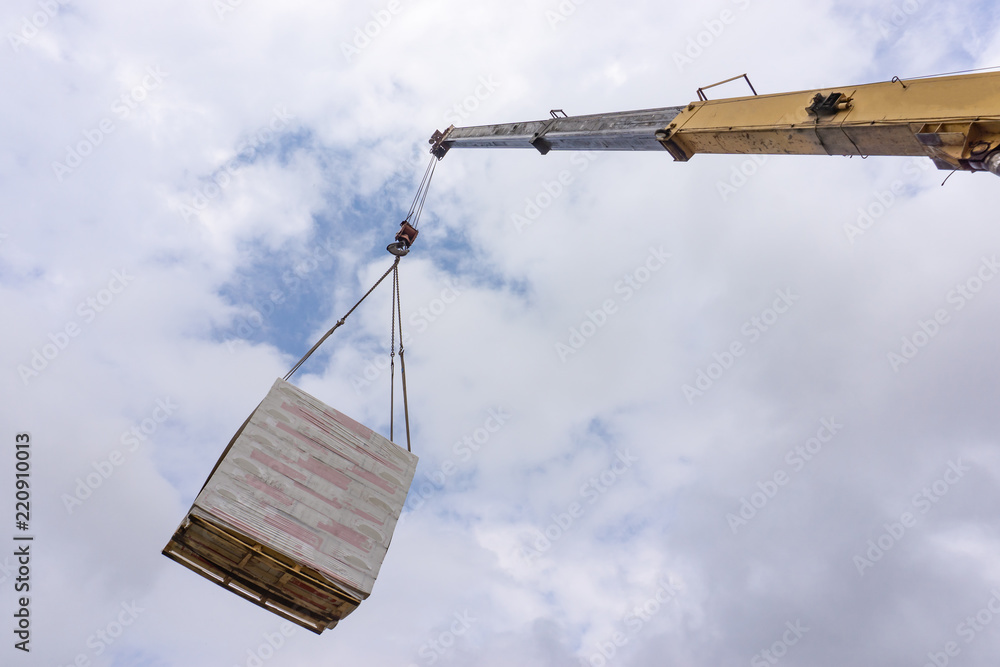 Unloading of building materials by crane at the construction site foto ...