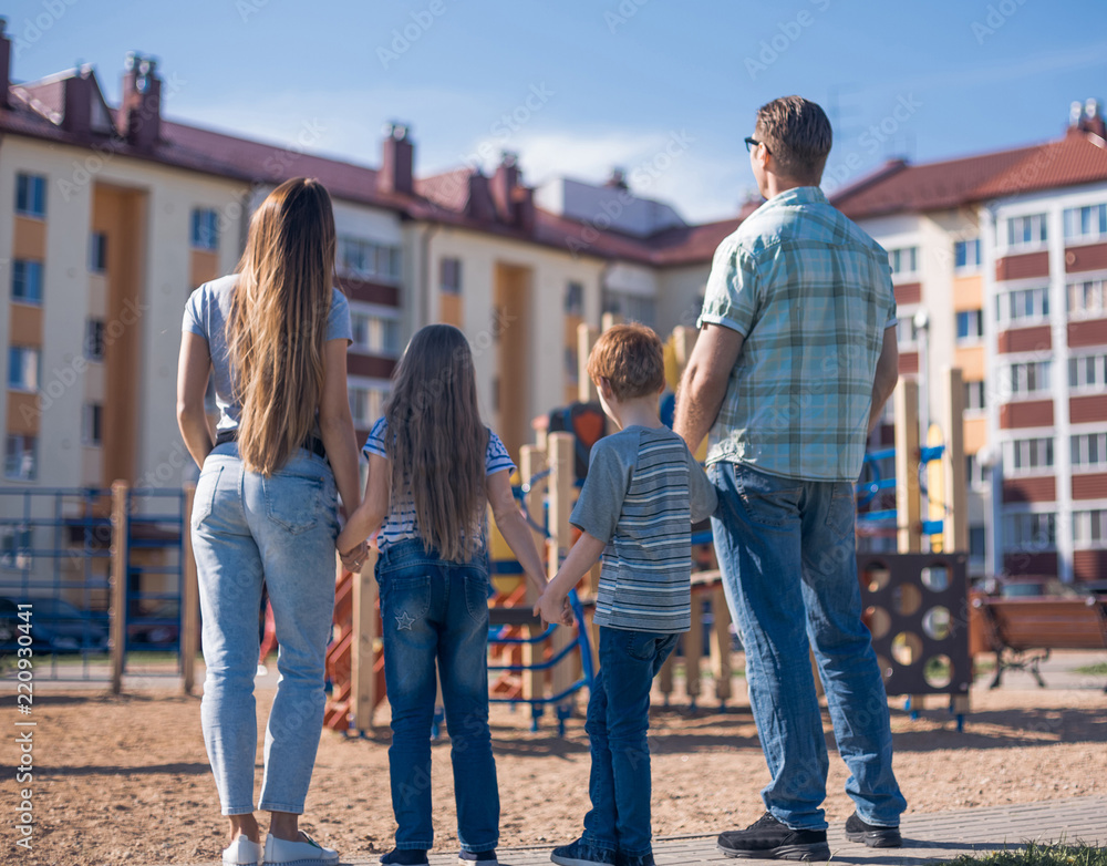 rear view.a young family is looking at a new apartment building Stock ...