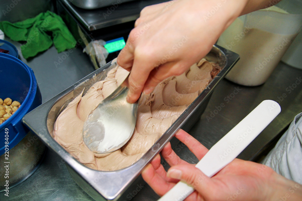 Woman working at ice cream factory is decorates of creamy ice cream of ...