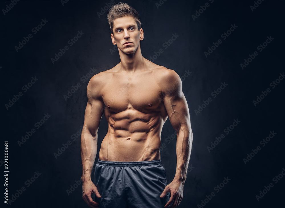 Handsome shirtless ectomorph bodybuilder with stylish hair posing on a ...