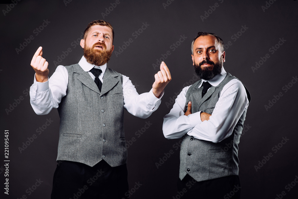 Two bearded men in suits talking and gesticulating to each other on ...