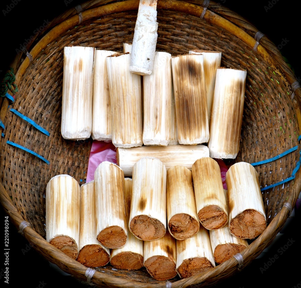 Aerial view of a wicker basket of bamboo tubes filled with sticky rice ...