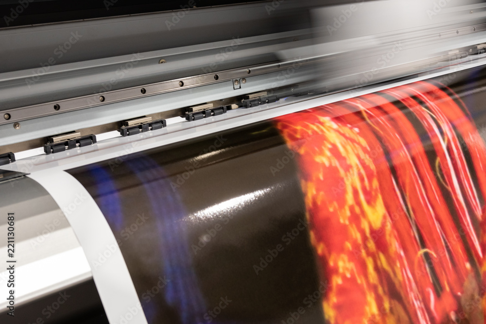 Big professional large scale printer, processing a glossy sheet of ...