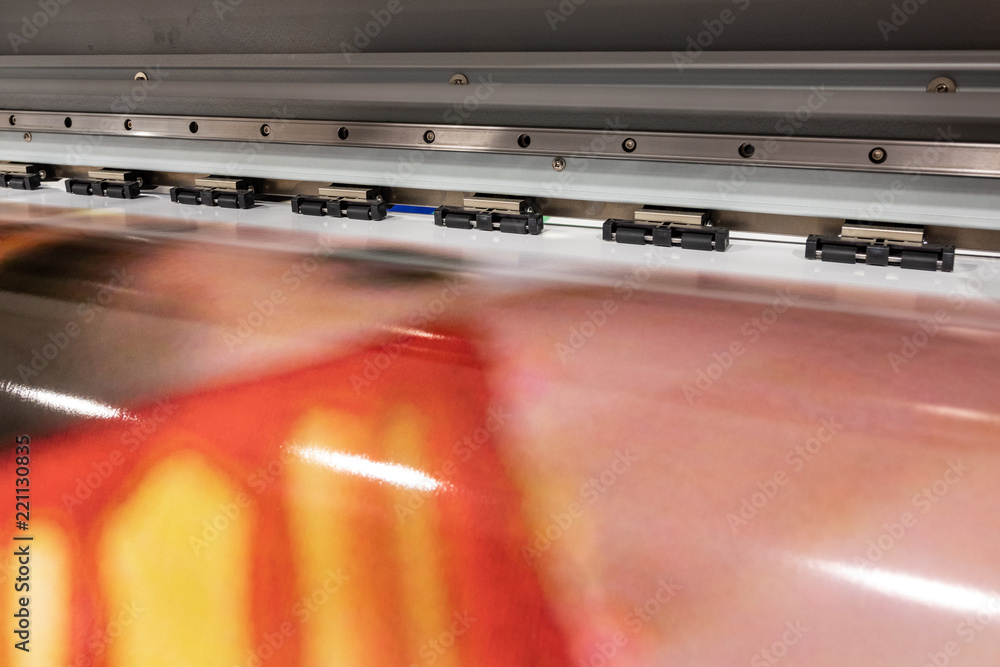 Big professional large scale printer, processing a glossy sheet of ...