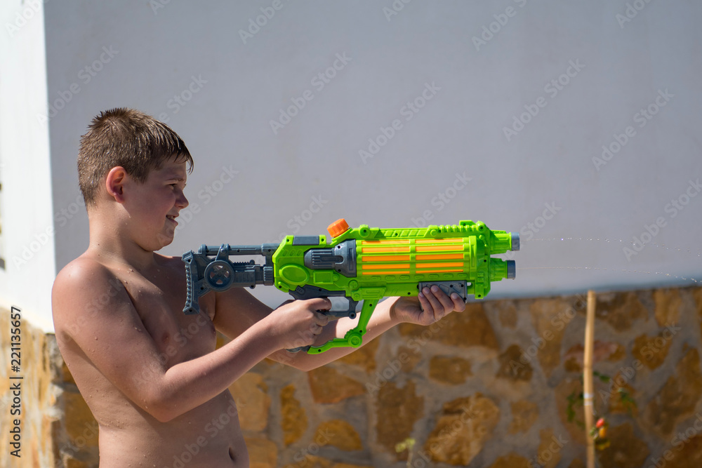 The boy play with water gun in the garden. Stock Photo | Adobe Stock