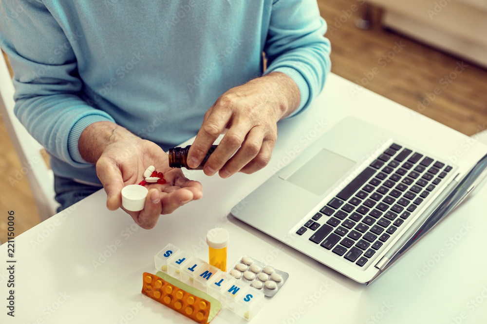 My daily dose. Top view on a hand of a retired gentleman sitting at a ...