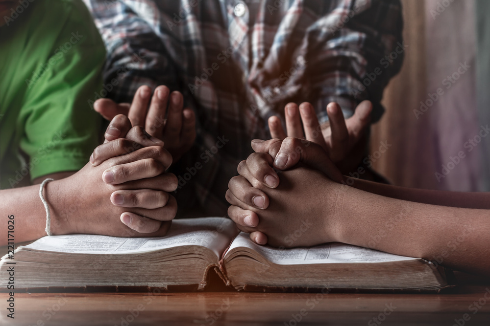 christian children group praying and worship on wooden table with open ...