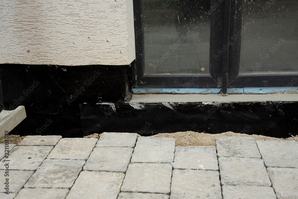 Waterproofing house foundation with spray on tar Stock Photo | Adobe Stock