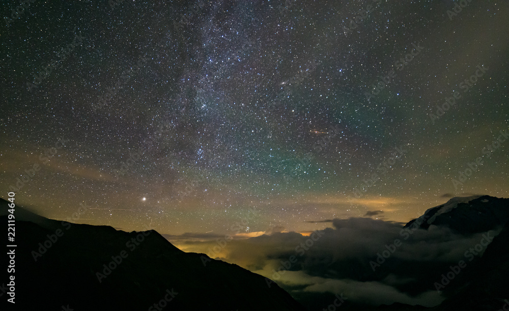 Clear panoramic view of the Milky Way above mount Ortler with clouds in ...