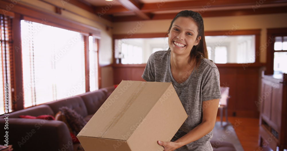 Joyful young woman in home carrying shipping box ready to deliver Stock ...