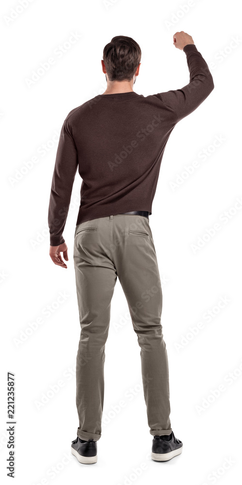 A fit man in casual sweater stands in a back view with one arm lifted ...