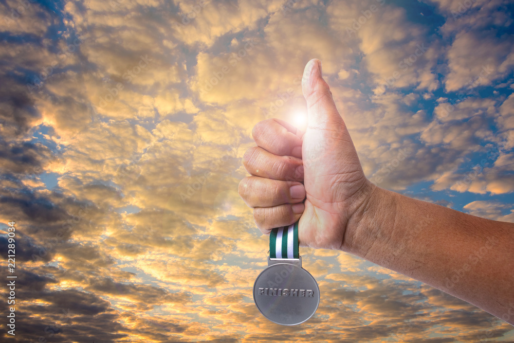 A hand and A golden medal. Hand is holding and the hand is putting the ...