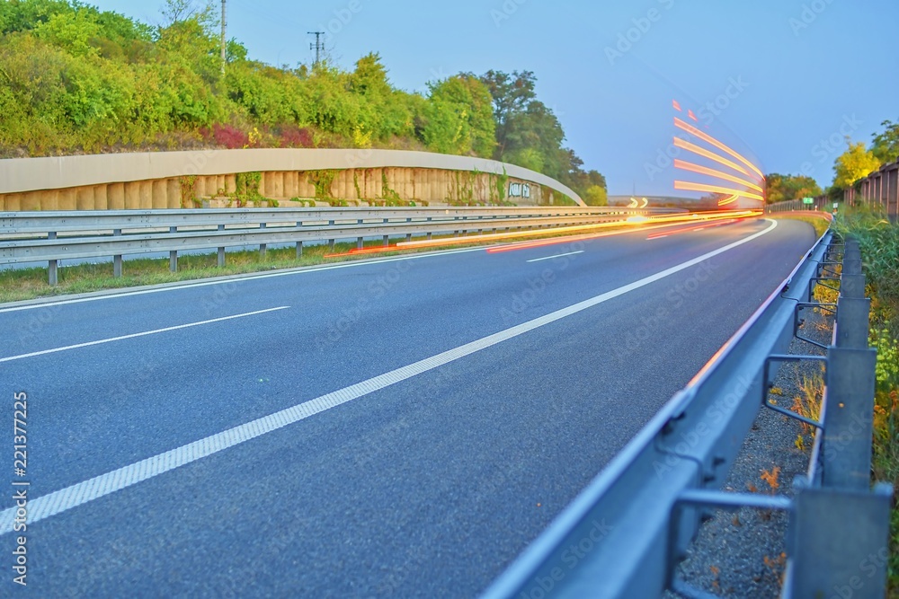 Highway at twilight with light trails. High traffic road with ...
