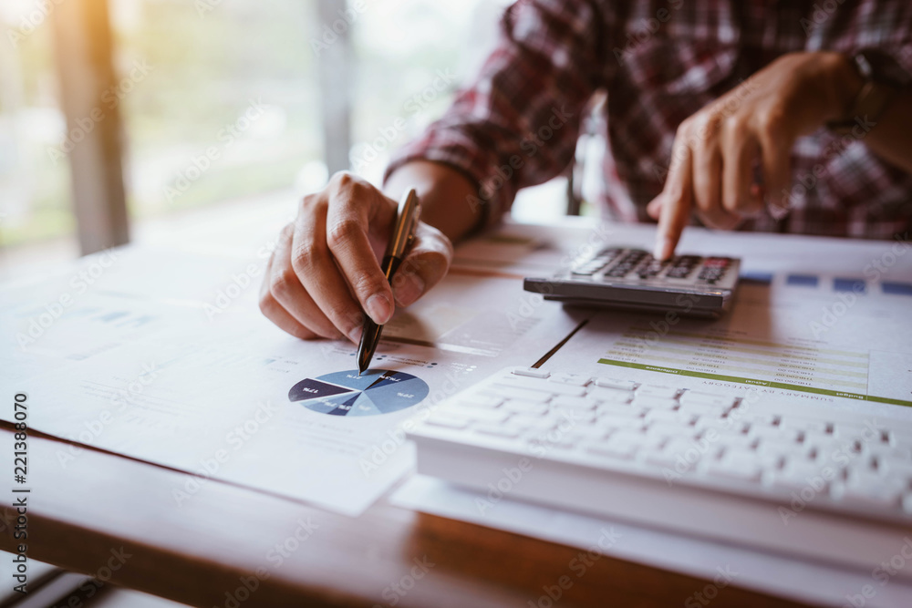 Businessman working on calculator to calculate business data the ...