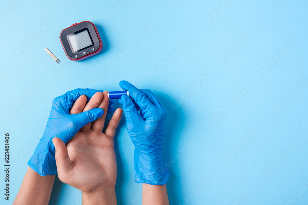 Nurse making a blood test with lancet. Man's hand with red blood drop ...