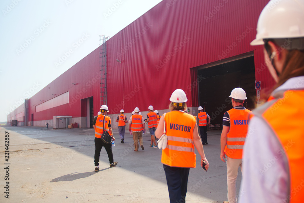 factory inspection. group of visitors on the factory tour. people go in ...