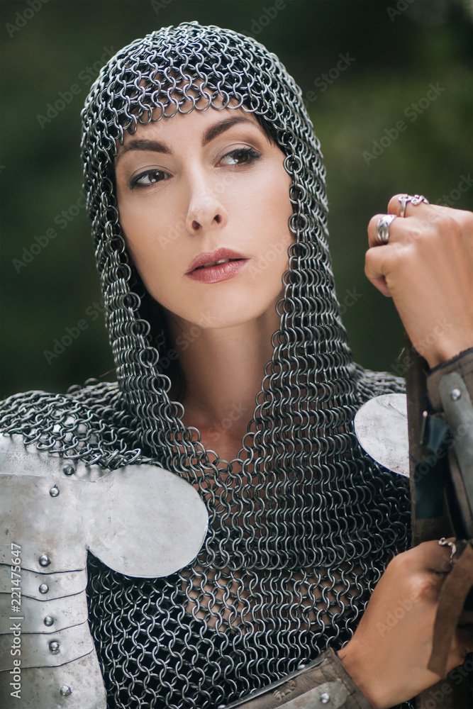 Medieval girl warrior, in a chain mail hood with a sword in his hand. A ...