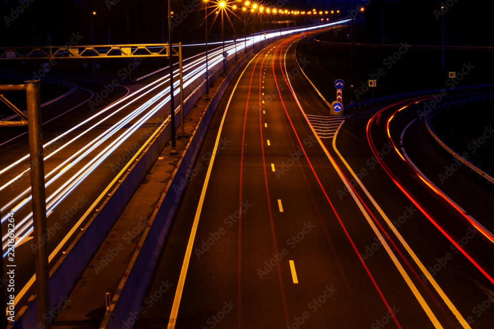 Cars light trails on a curved highway at night. Night traffic trails ...