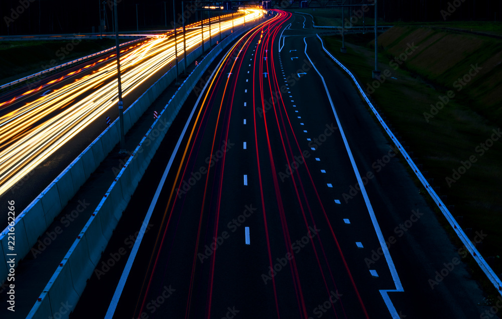 Cars light trails on a curved highway at night. Night traffic trails ...