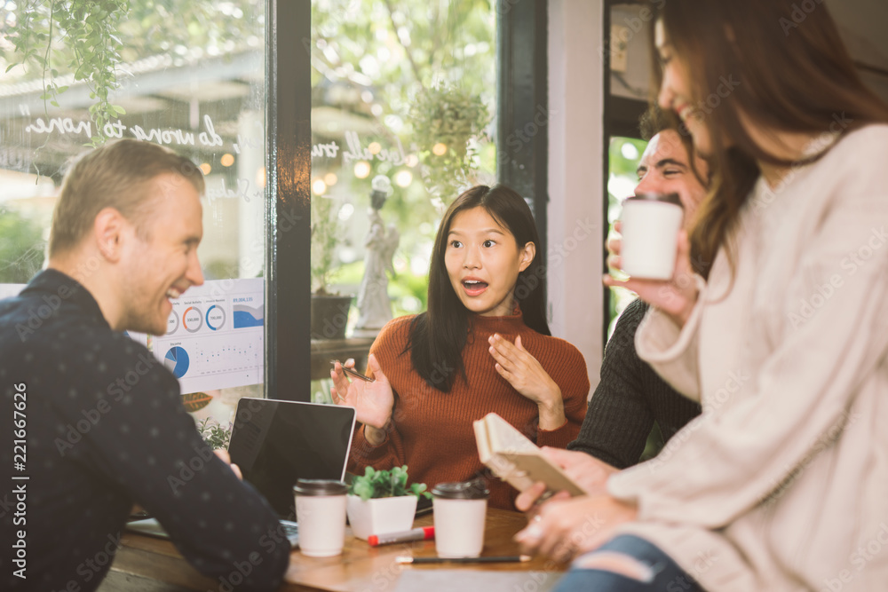 Group of friends chatting and using laptop in cafe at the coffee shop ...