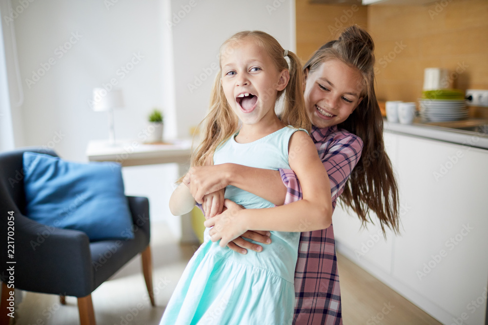 Two little adorable girls in dresses having fun in the kitchen and ...