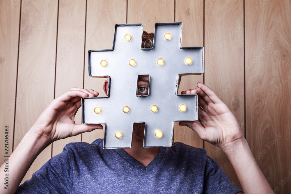 Teen with hashtag symbol in front of his face peeking out Stock Photo ...