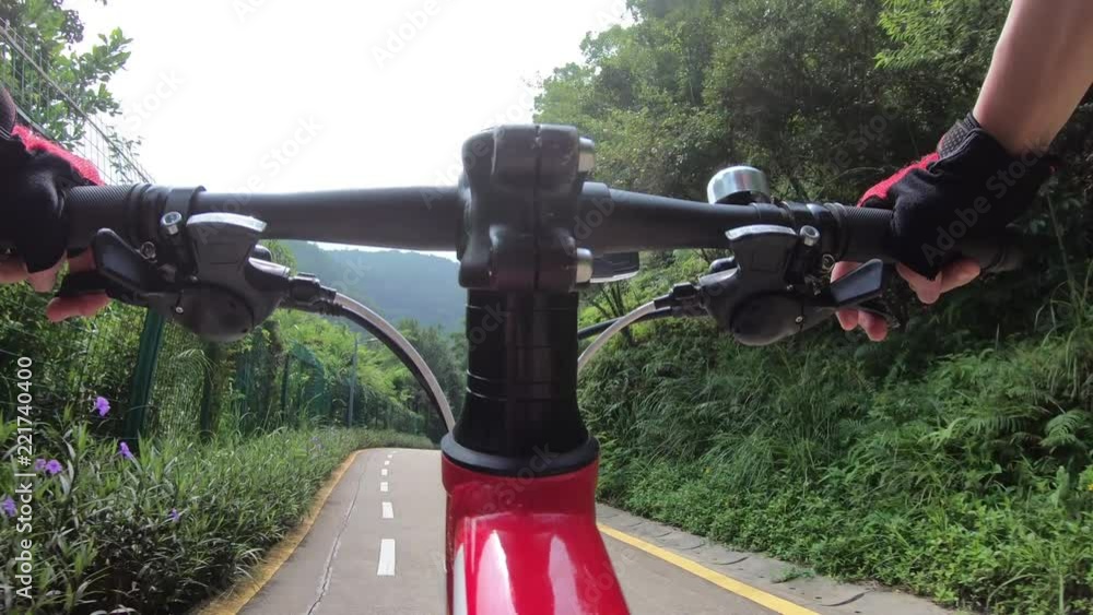 Riding bike on bicycle path in park, View from first person perspective ...