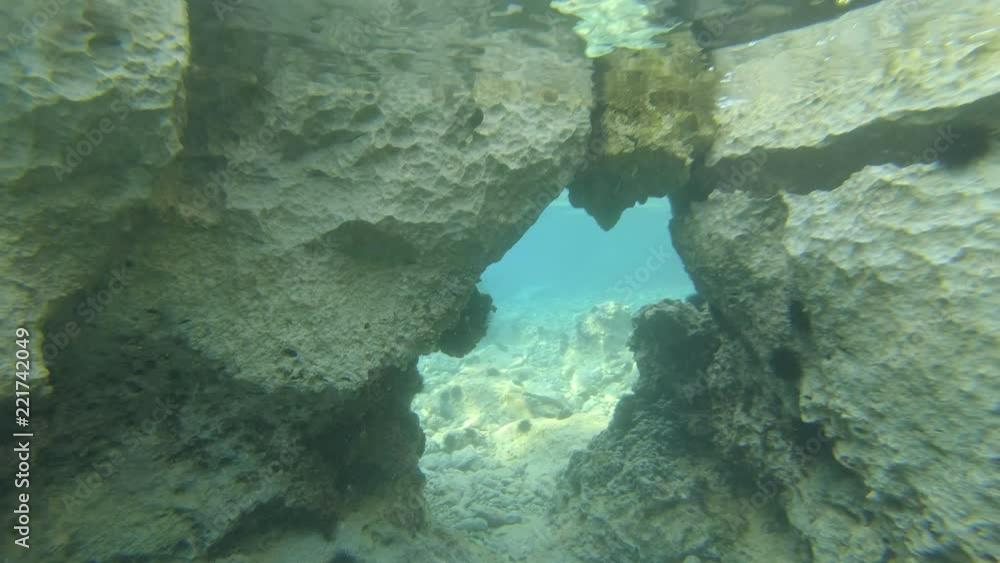 View of a cave in sea rock showing seabed on the other side. 4k ...