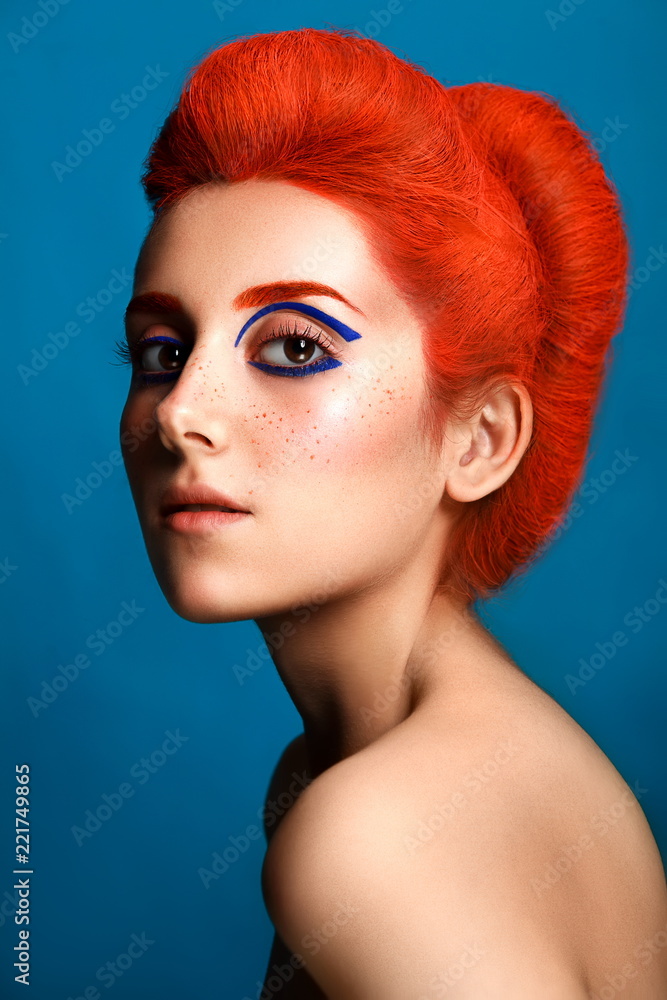 beautiful young girl with bright red hair and freckles with modern blue ...