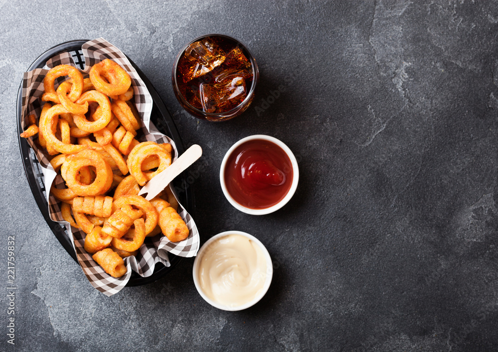 Curly fries fast food snack in red plastic tray with glass of cola and ...