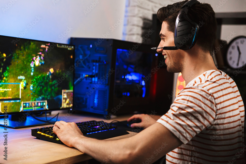 Portrait of professional gamer guy playing video games on computer ...