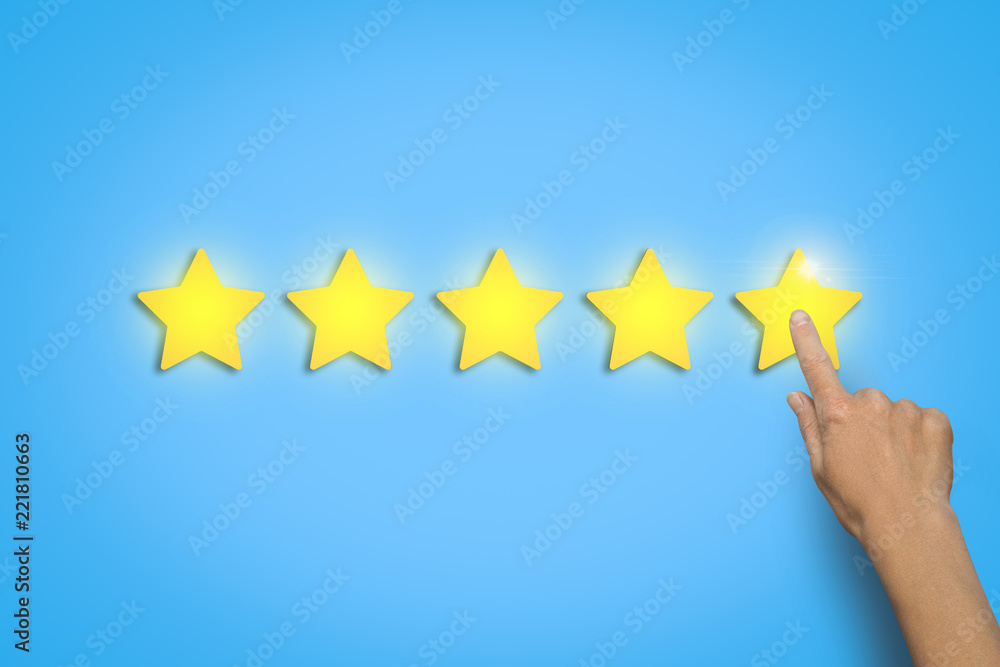 Female hand leaves a rating of five stars out of five possible o Stock ...