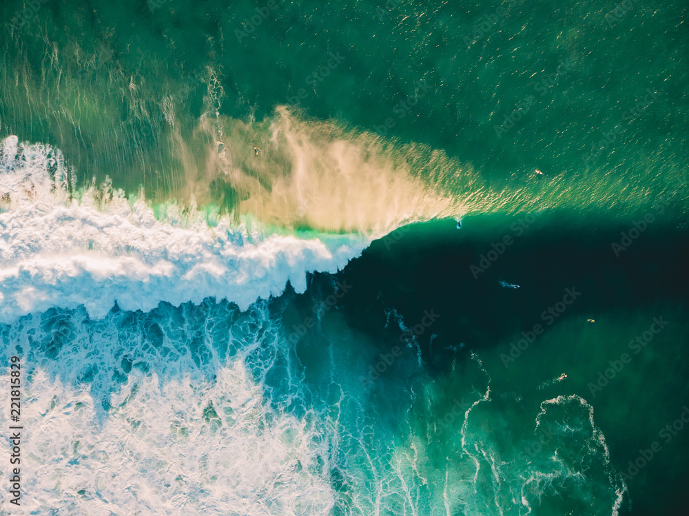 Aerial view of crashing wave in ocean with warm sunset light. Wave ...