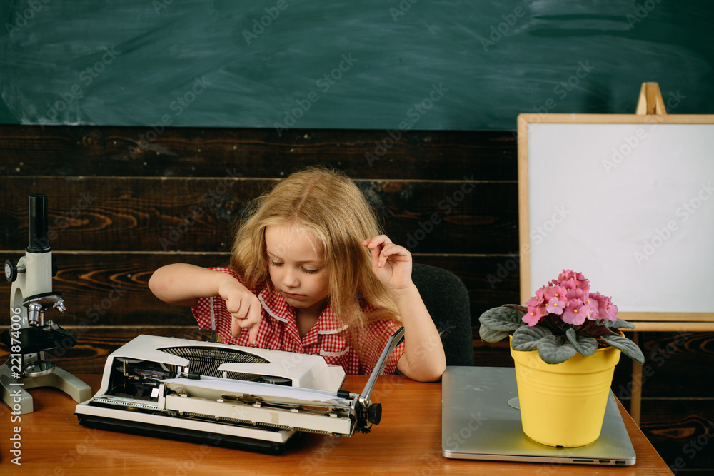 Pupil type on typewriter in school class. Elementary school pupil enjoy ...
