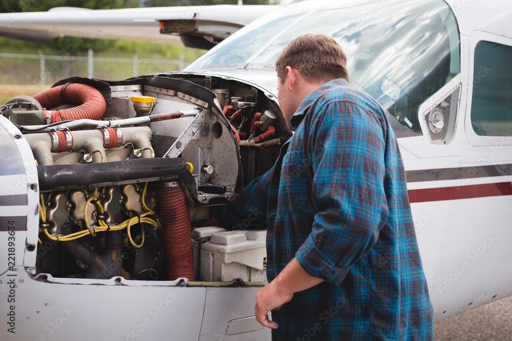 Engineer servicing aircraft engine near hangar Stock Photo | Adobe Stock