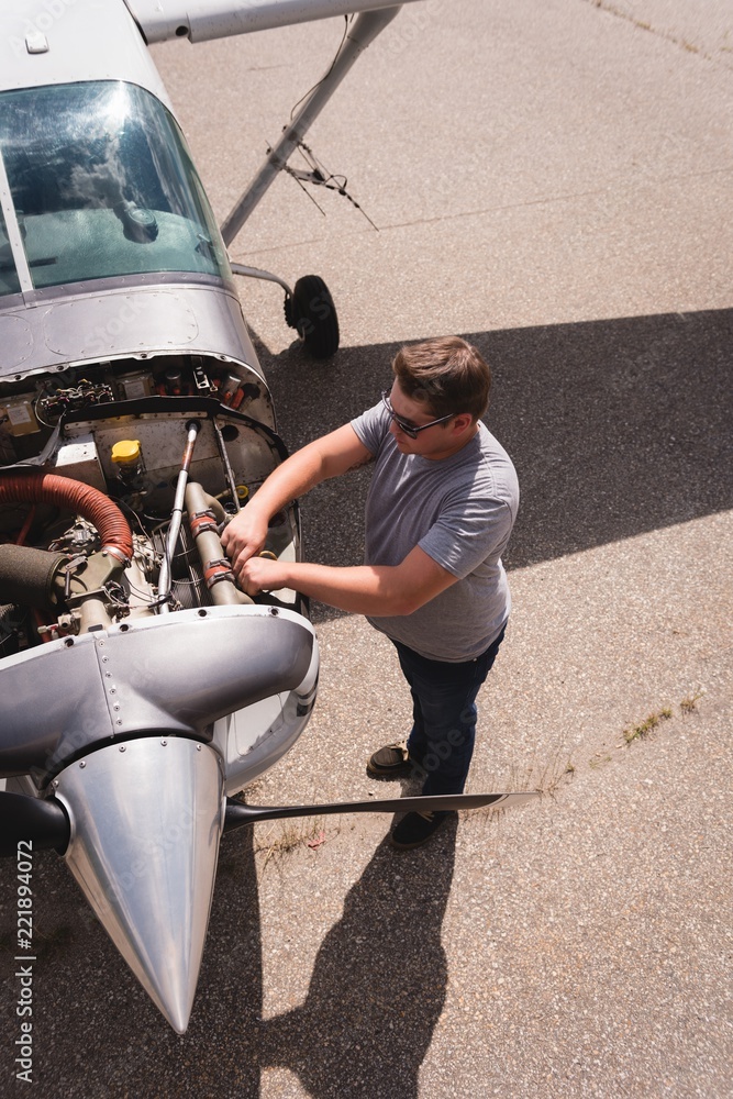 Engineer servicing aircraft engine near hangar Stock Photo | Adobe Stock
