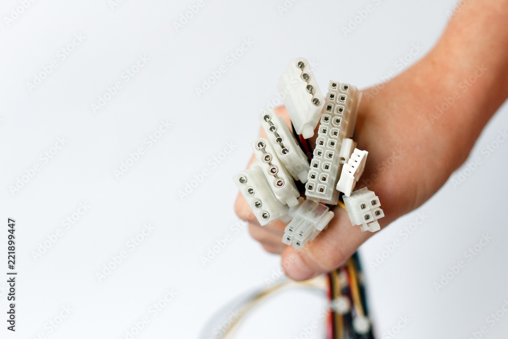hand holds power cables from power supply unit on white background, PC ...
