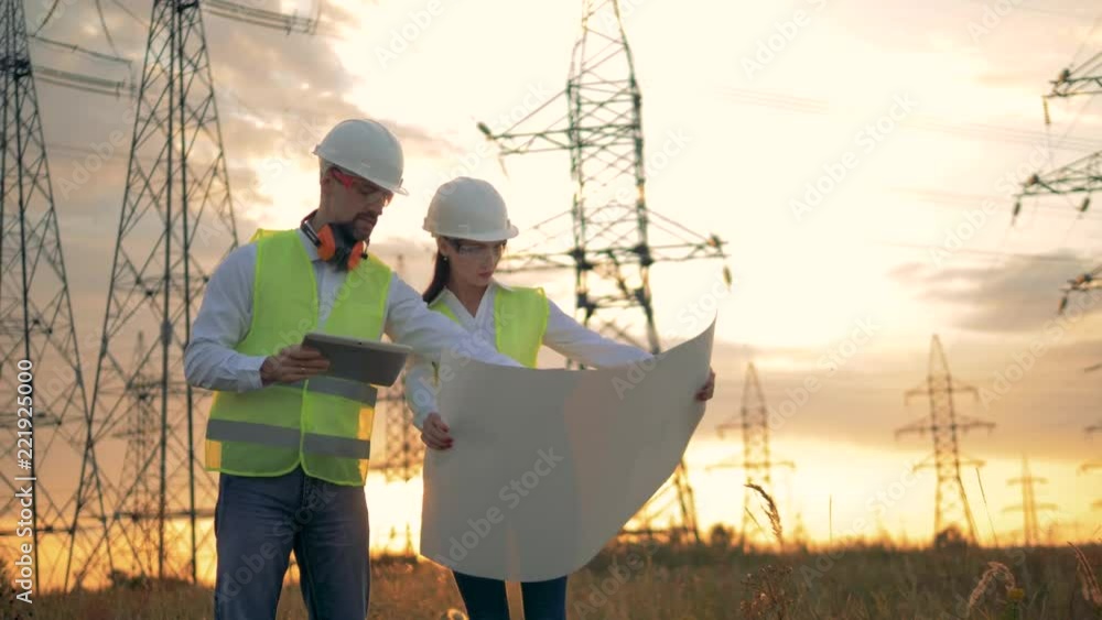 People working at a power line on a sunset background, close up. Stock ...