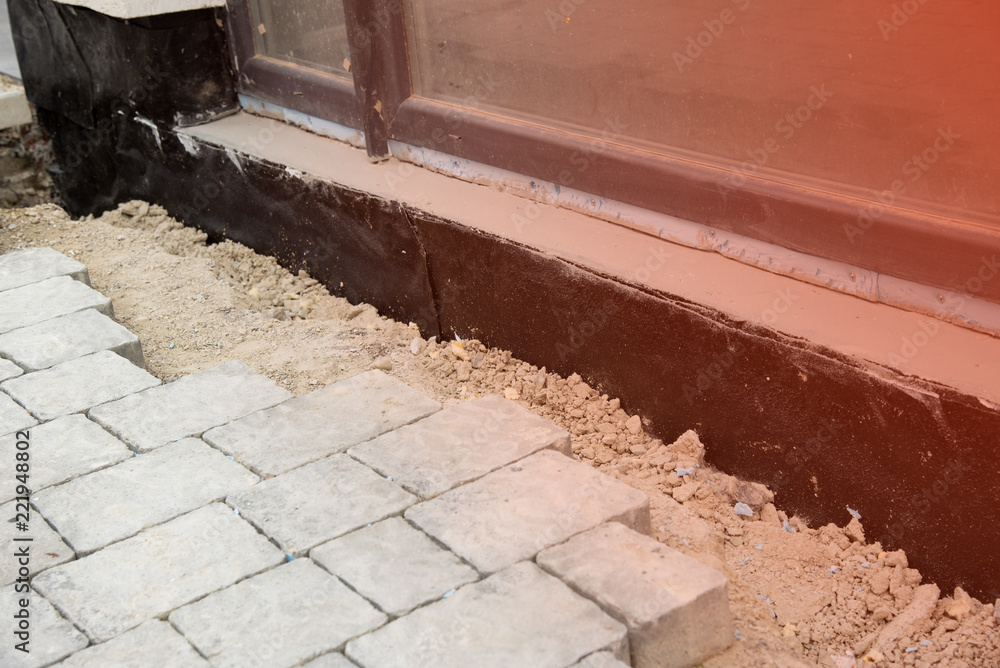 Waterproofing house foundation with spray on tar Stock Photo | Adobe Stock