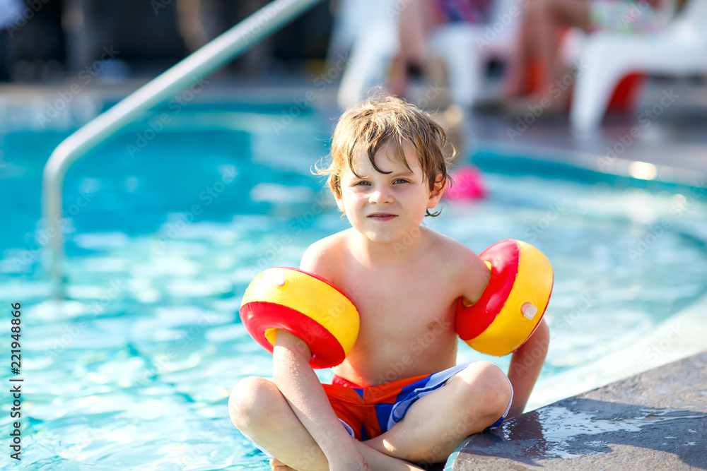 Happy little kid boy having fun in an swimming pool. Active happy child ...