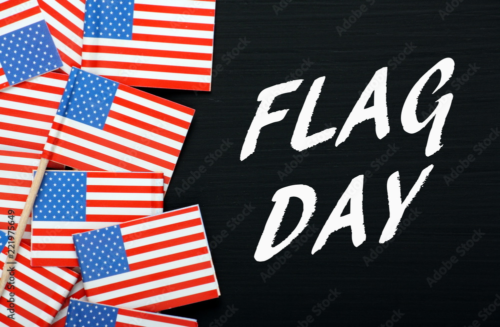 The words Flag Day on a blackboard next to miniature flags of the ...