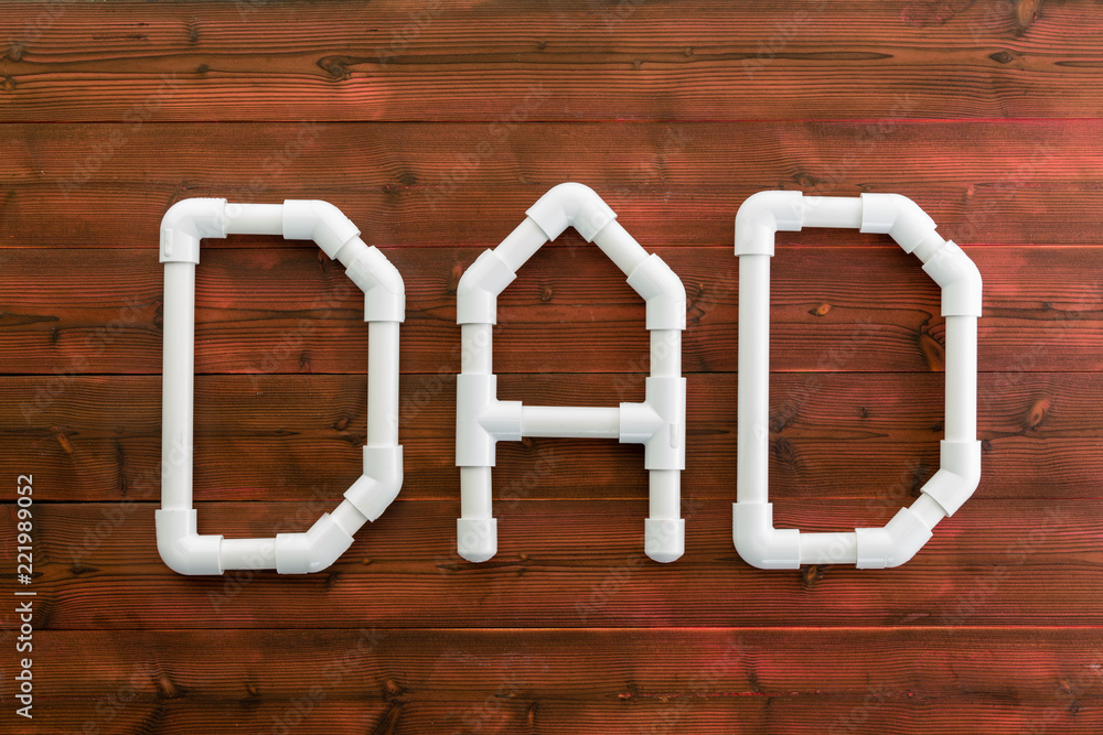 Word Dad formed of white PVC pipes on wood Stock Photo | Adobe Stock