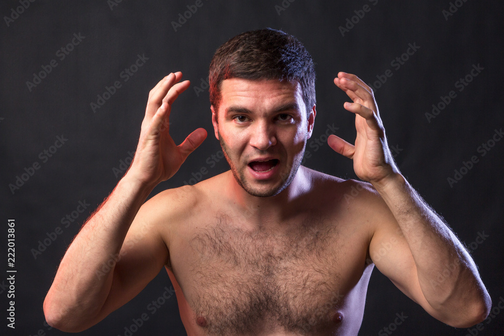 Man grabs his head with his hands and screams from overexertion ...