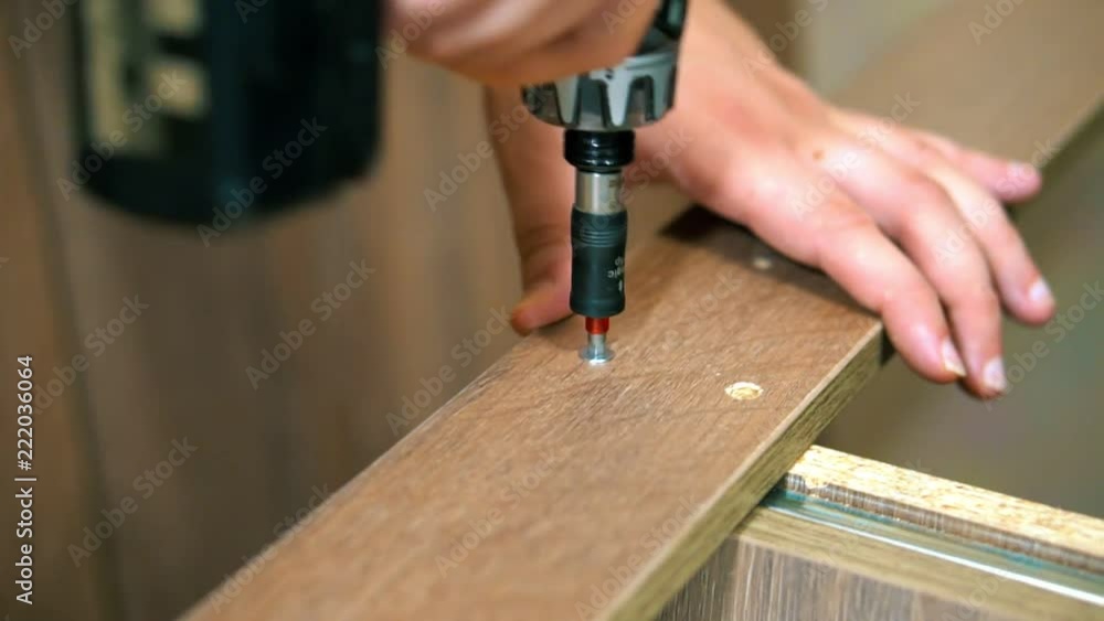 Fastening the panel with a screw using a screwdriver. Hand screwdriver ...