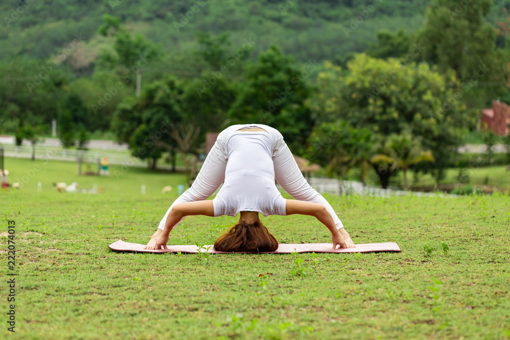 Beautiful Attractive Asian woman practice yoga Spread foot stretching ...