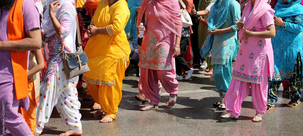Sikh women dressed in traditional clothes walk barefoot on the s Stock ...