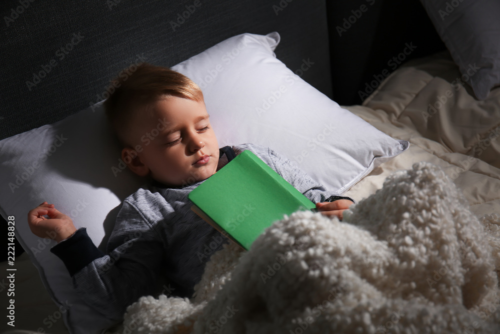 Cute little boy with book sleeping in bed at home Stock Photo | Adobe Stock